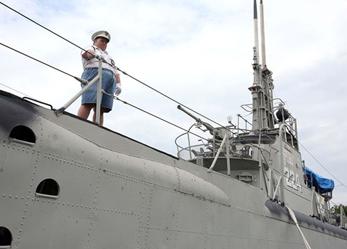 Men take their hats off in honor of the 70 crewmen who died on the ...